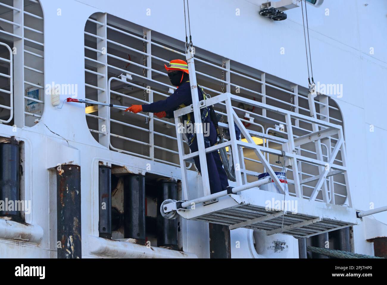 Sailor painting side of cruise ship Stock Photo - Alamy
