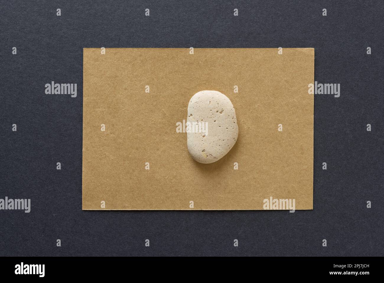 brick pebble isolated on gold or sand brown card and grey paper Stock ...