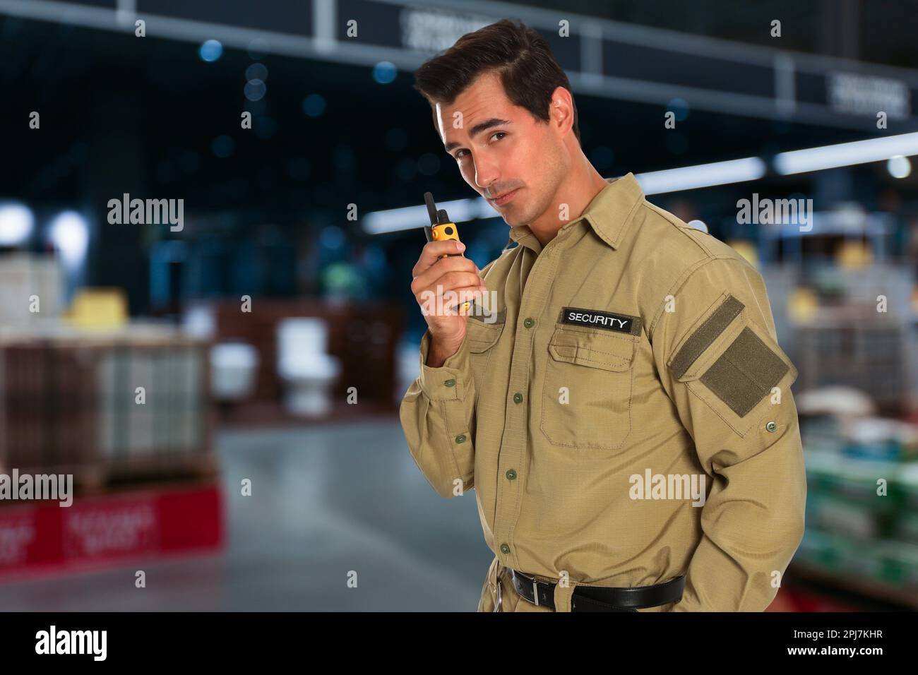 Male security guard wearing uniform using portable radio transmitter in ...