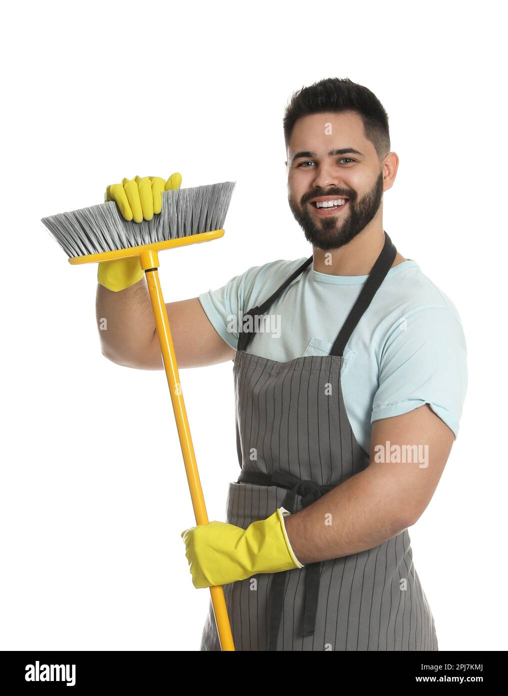 Young man with yellow broom on white background Stock Photo - Alamy