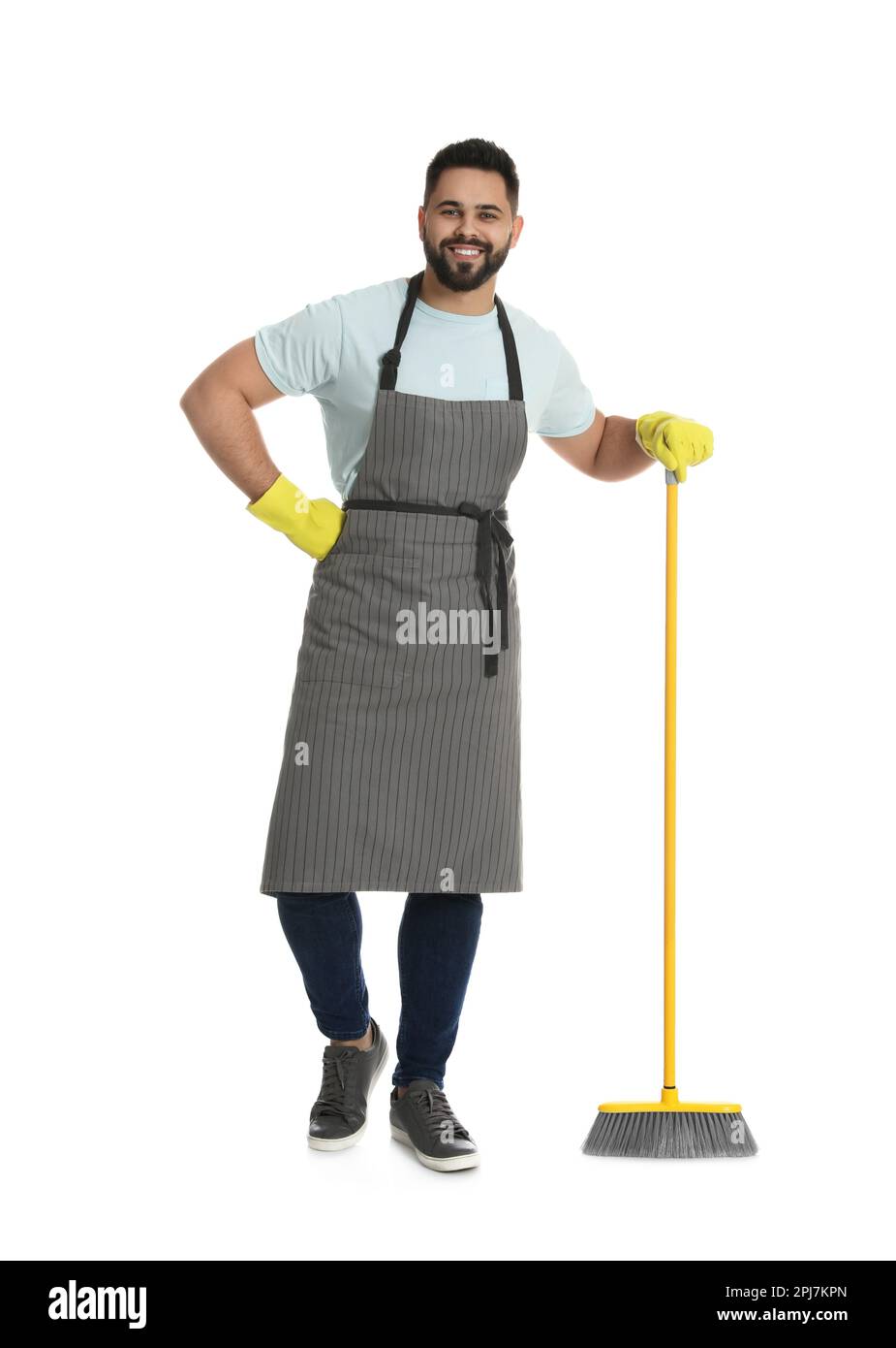 Young man with yellow broom on white background Stock Photo - Alamy