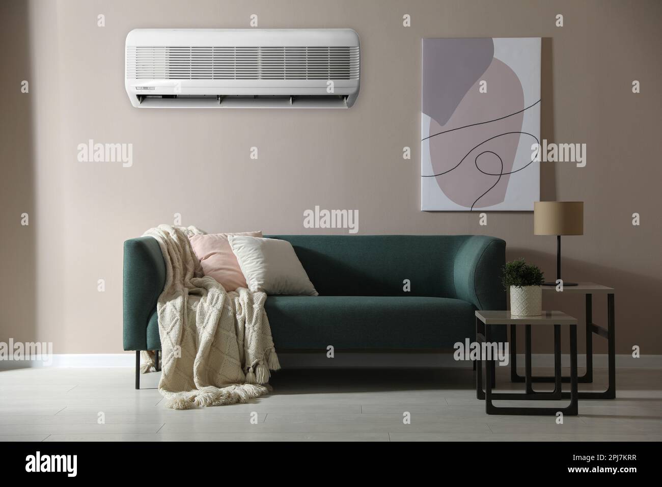 Modern air conditioner on beige wall in room with stylish sofa Stock ...