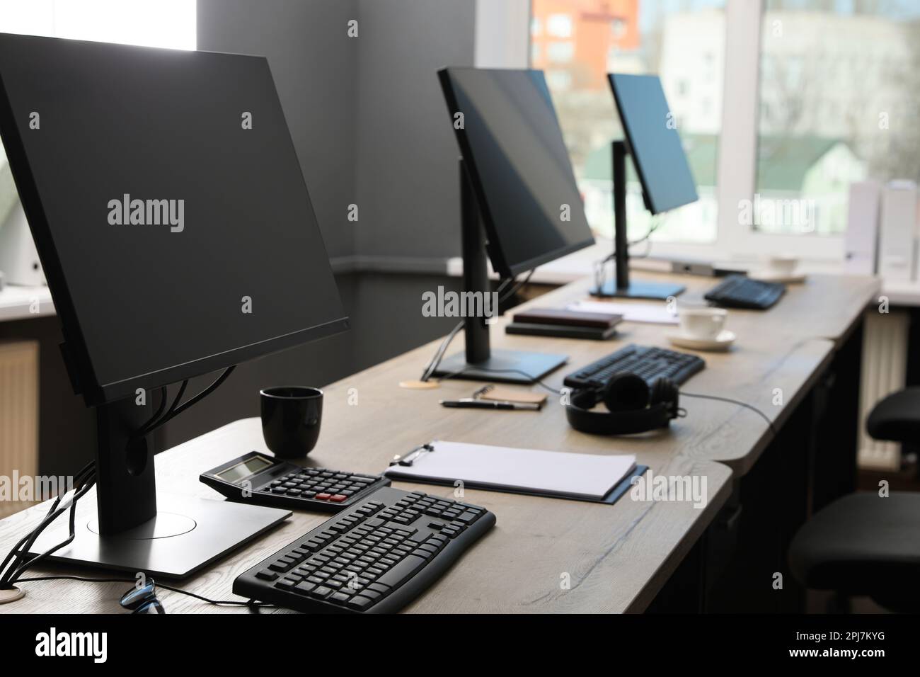 Open office interior. Modern workplaces with computers near window ...