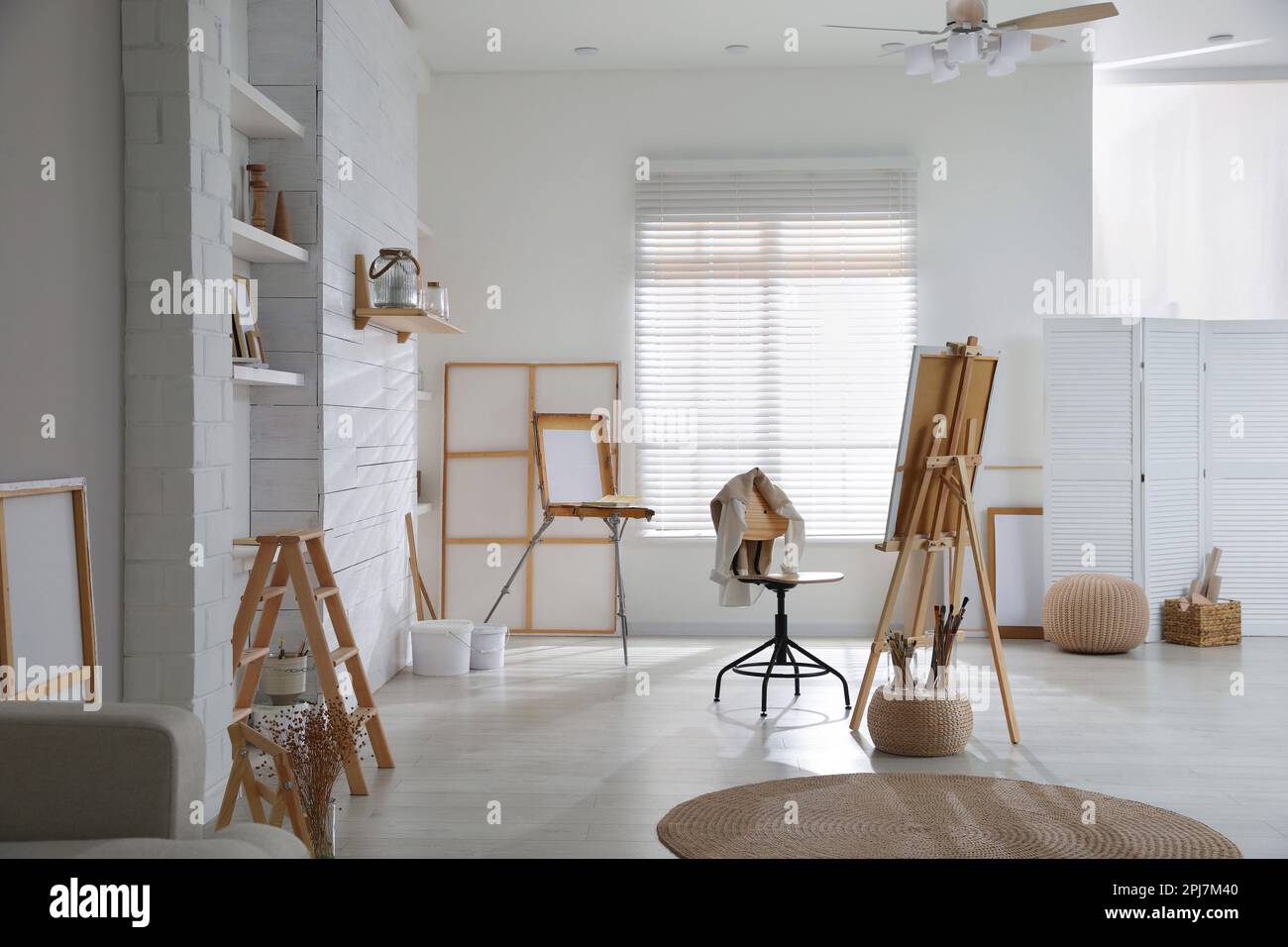 Modern studio interior with artist's workplace and foldable wooden ...