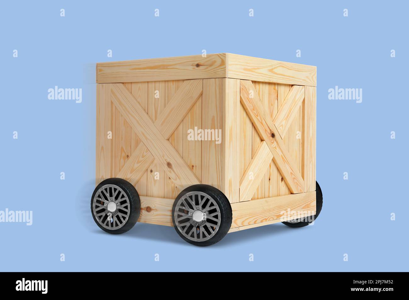 Wooden box on wheels against light blue background. Transportation and ...