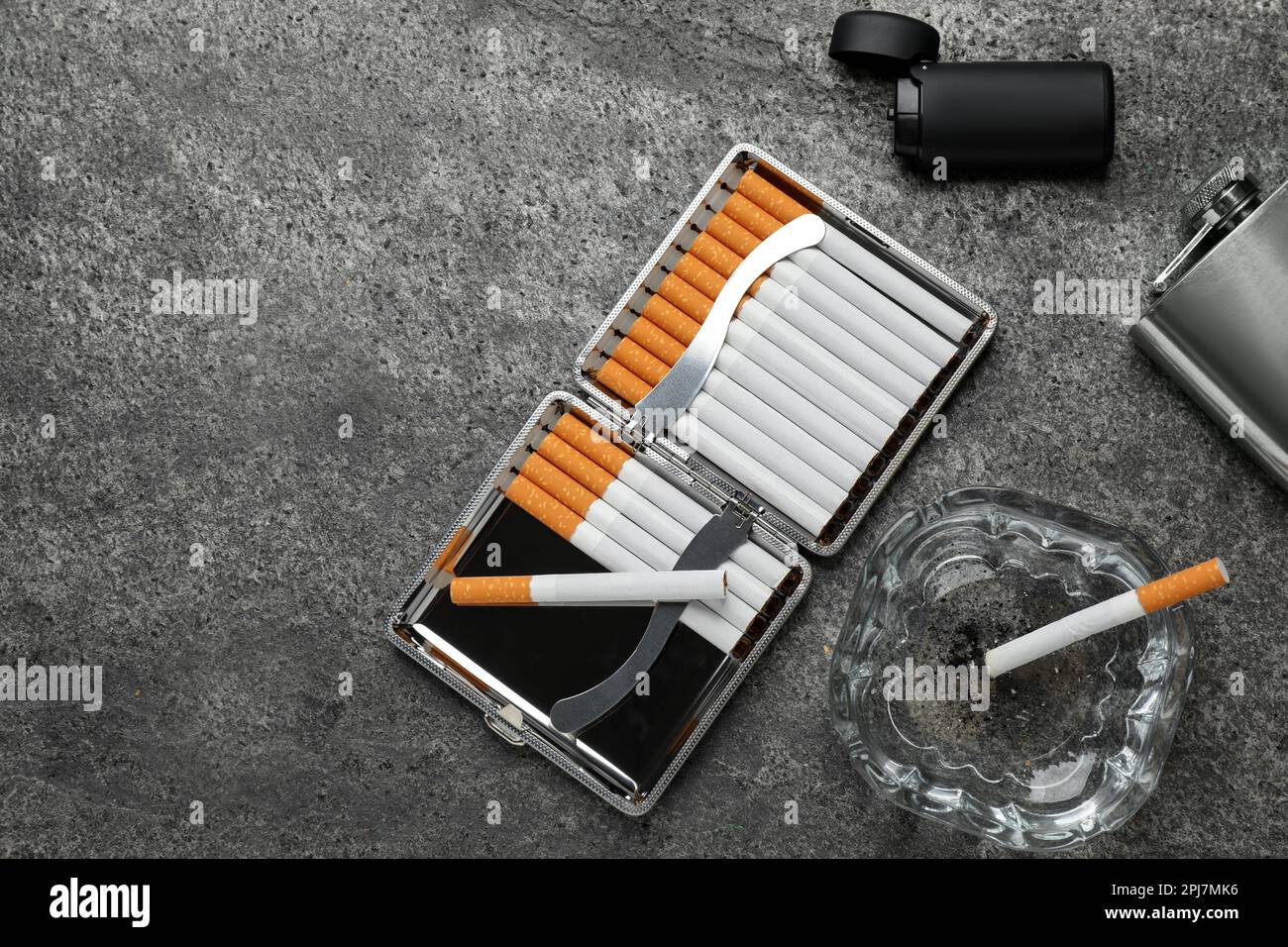 Open case with tobacco filter cigarettes, lighter, glass ashtray and ...
