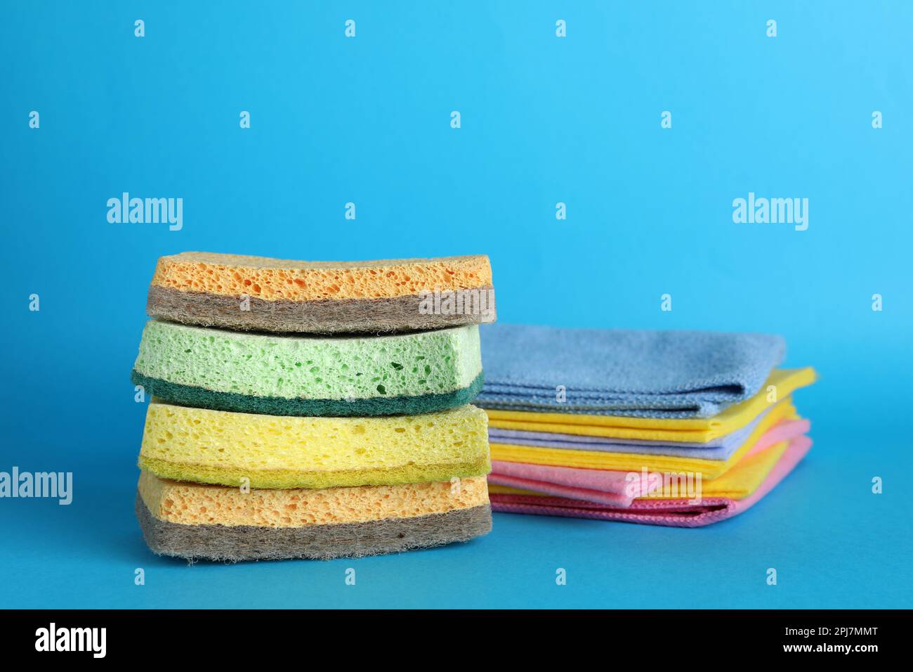 Color sponges and rags on light blue background Stock Photo - Alamy