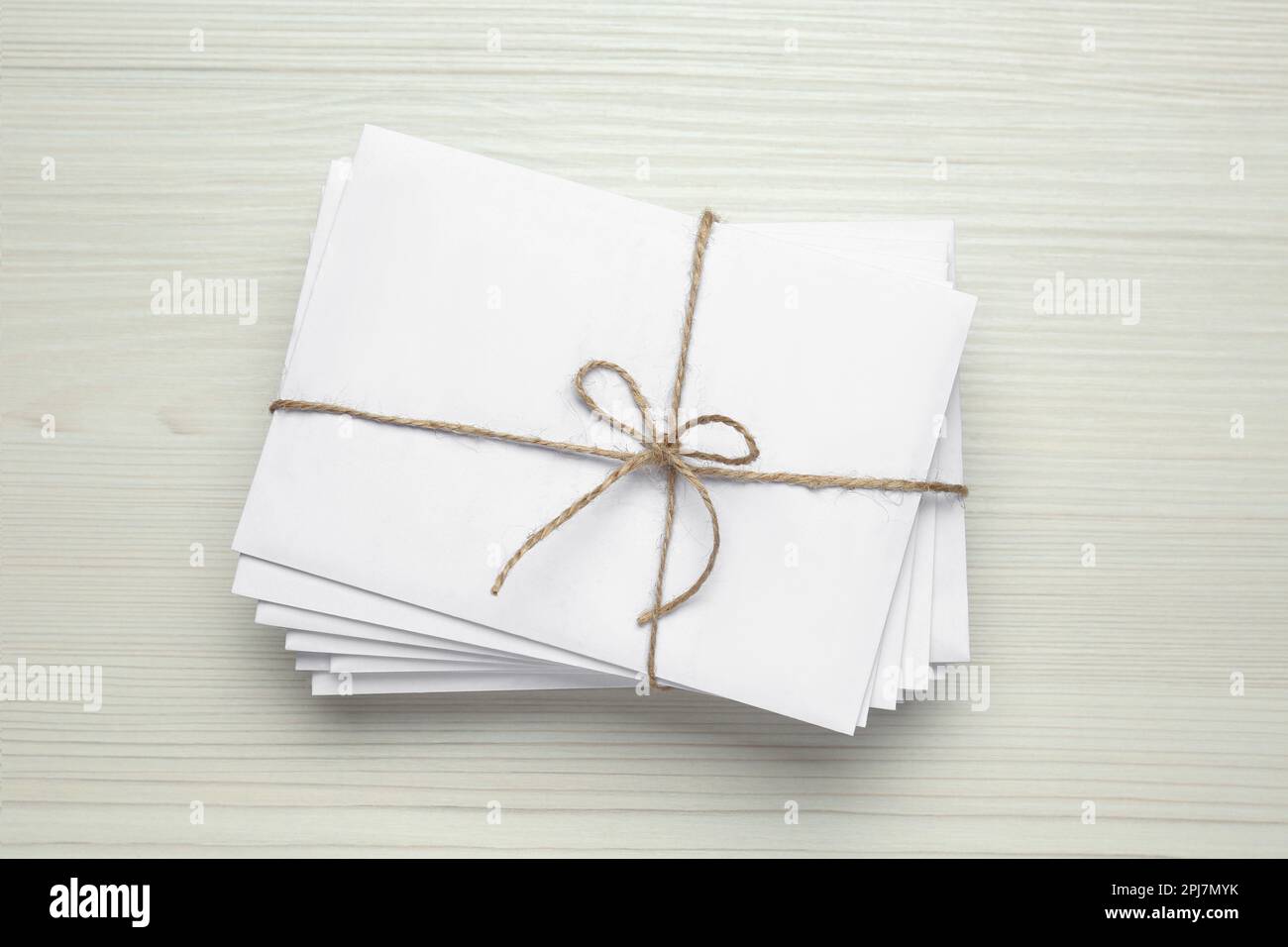 Stack of letters tied with twine on white wooden table, top view Stock ...