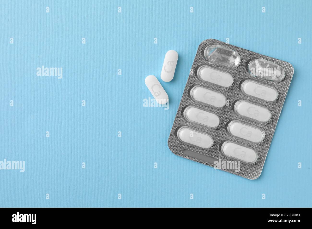 Blister pack with calcium supplement pills on light blue background ...