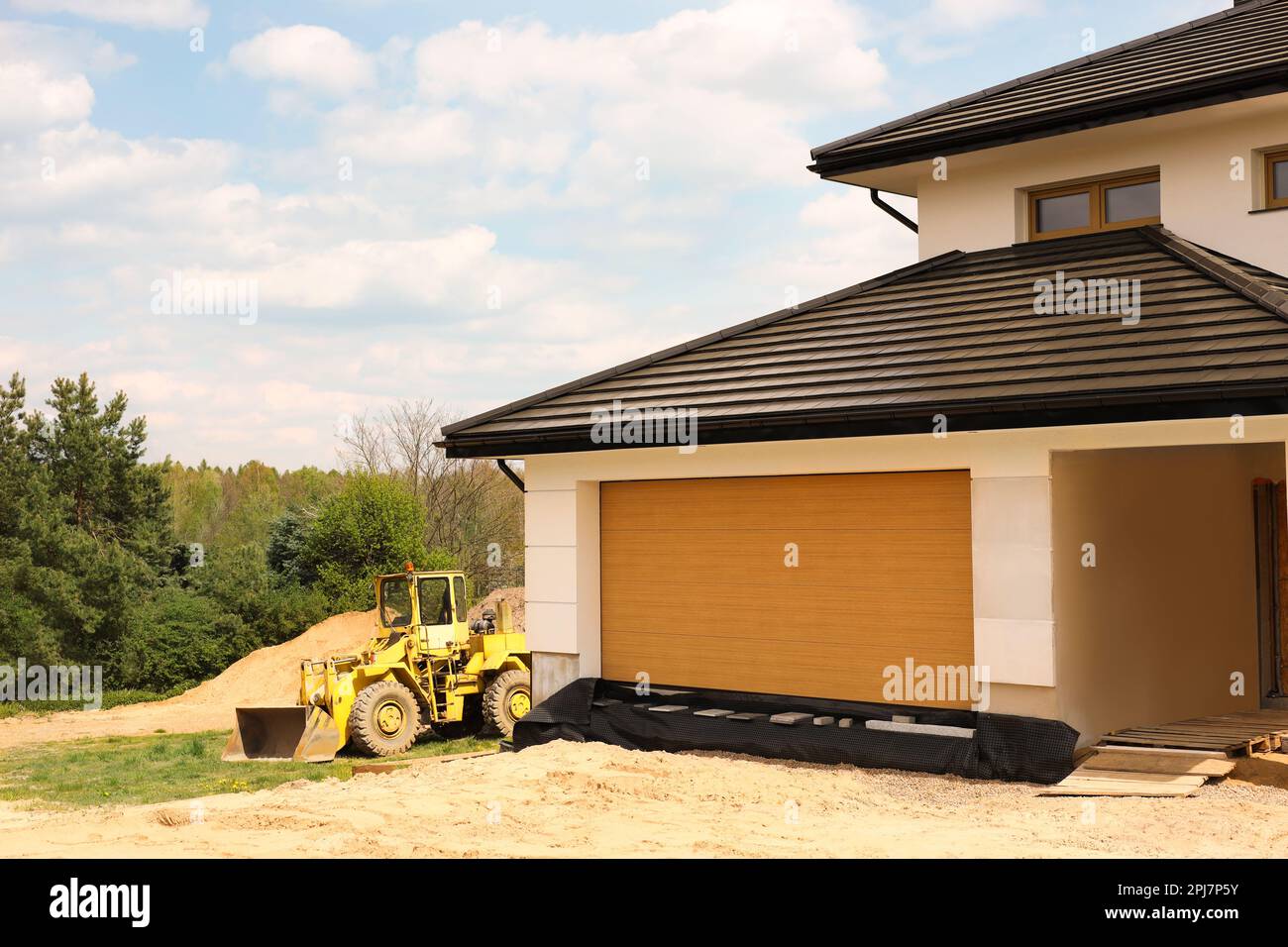 Modern loader near house on sunny day Stock Photo - Alamy