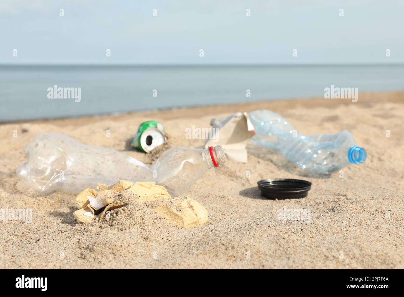 Garbage scattered on beach near sea, closeup. Recycling problem Stock ...