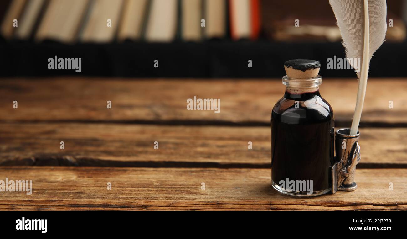 Quill and bottle of ink on wooden table, space for text. Banner design ...