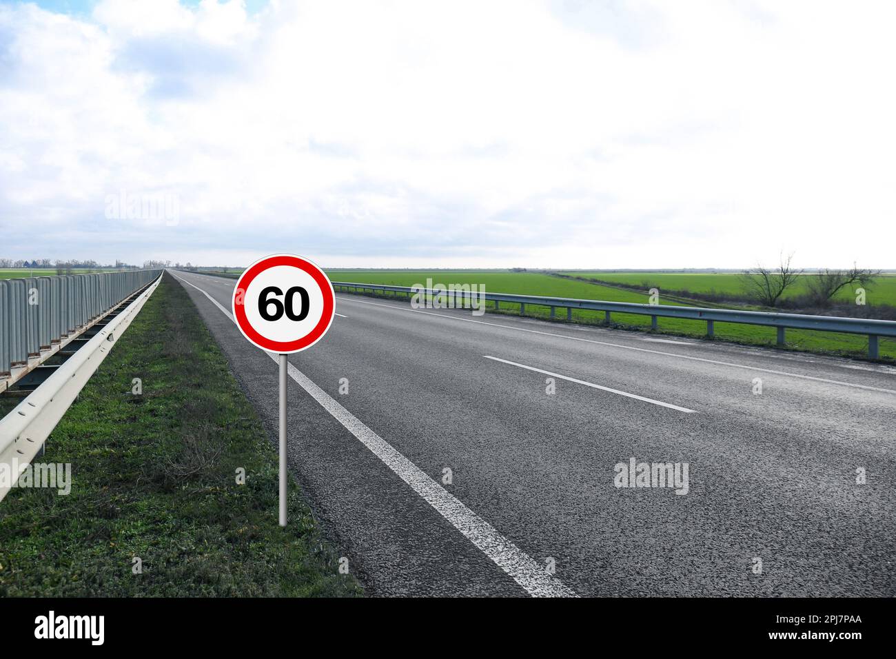 Traffic sign MAXIMUM SPEED 60 near empty asphalt road Stock Photo - Alamy