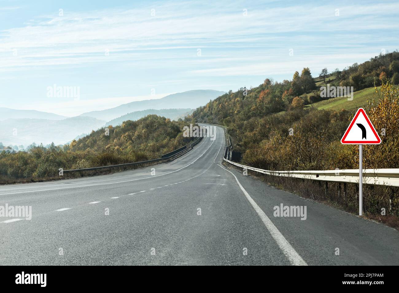 Traffic sign BEND TO LEFT near empty asphalt road Stock Photo - Alamy