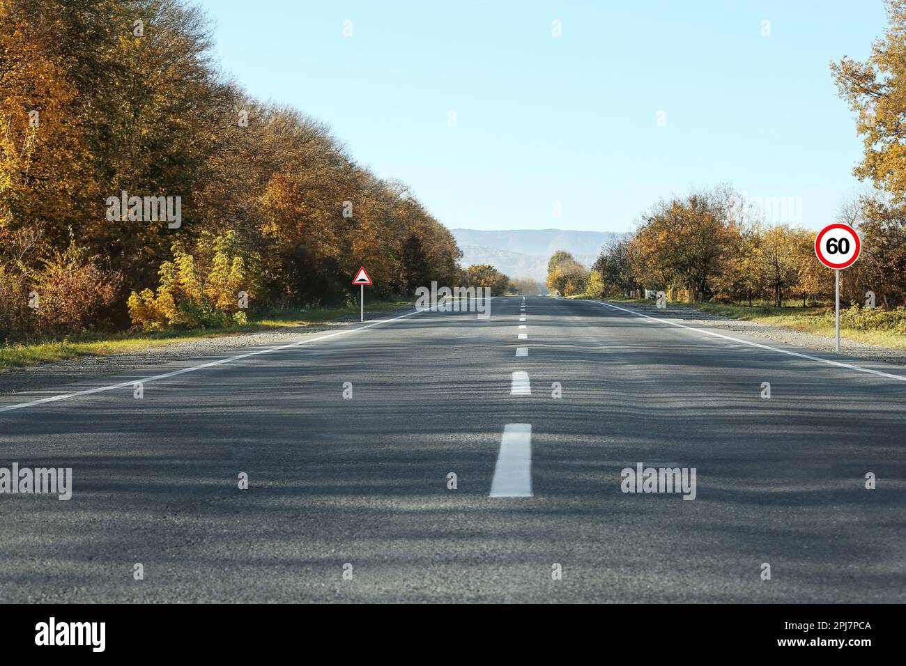 Traffic signs MAXIMUM SPEED 60 and Speed Bump near empty asphalt road ...