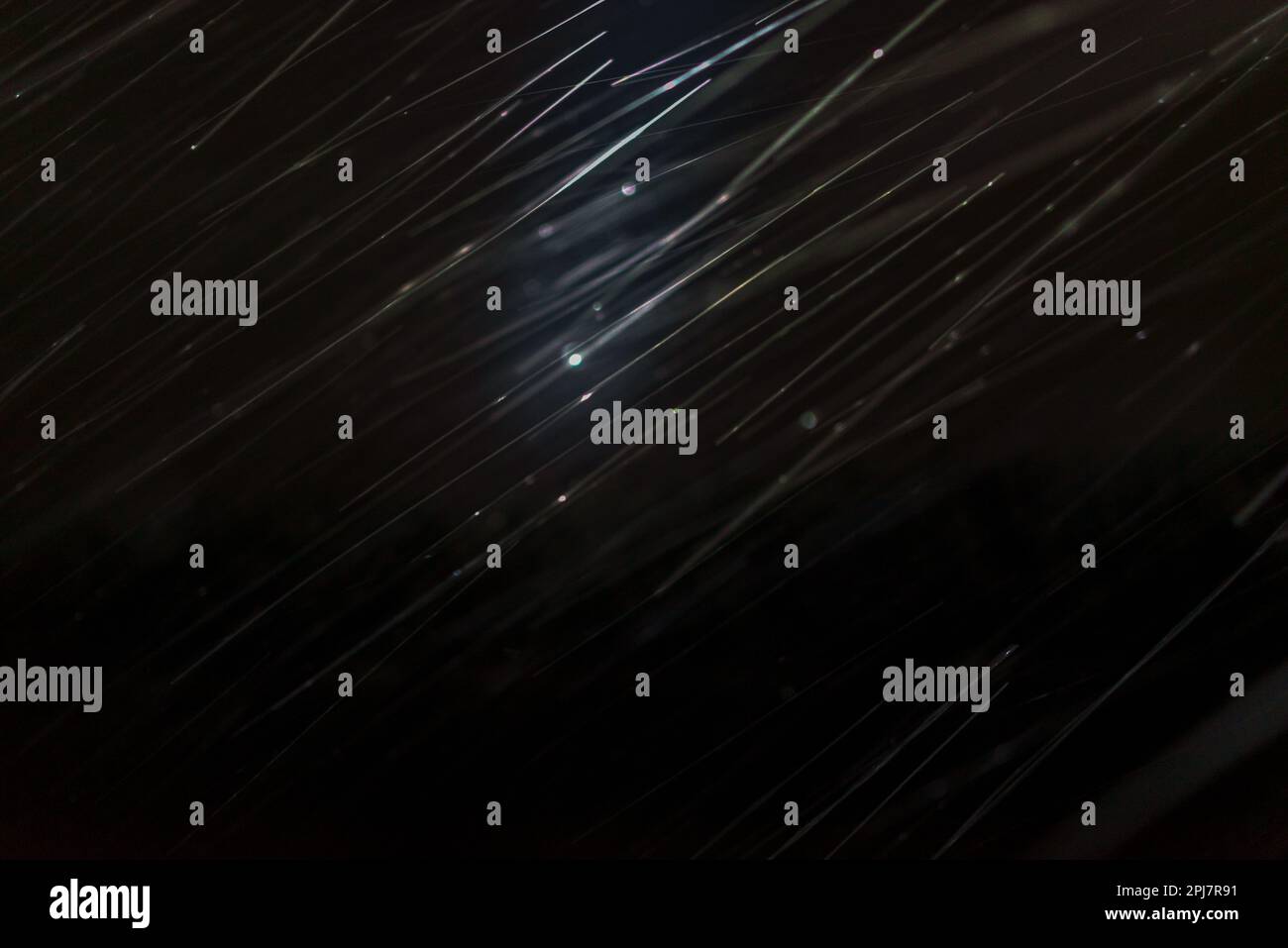 Falling streaks from white snow falling at night Stock Photo - Alamy