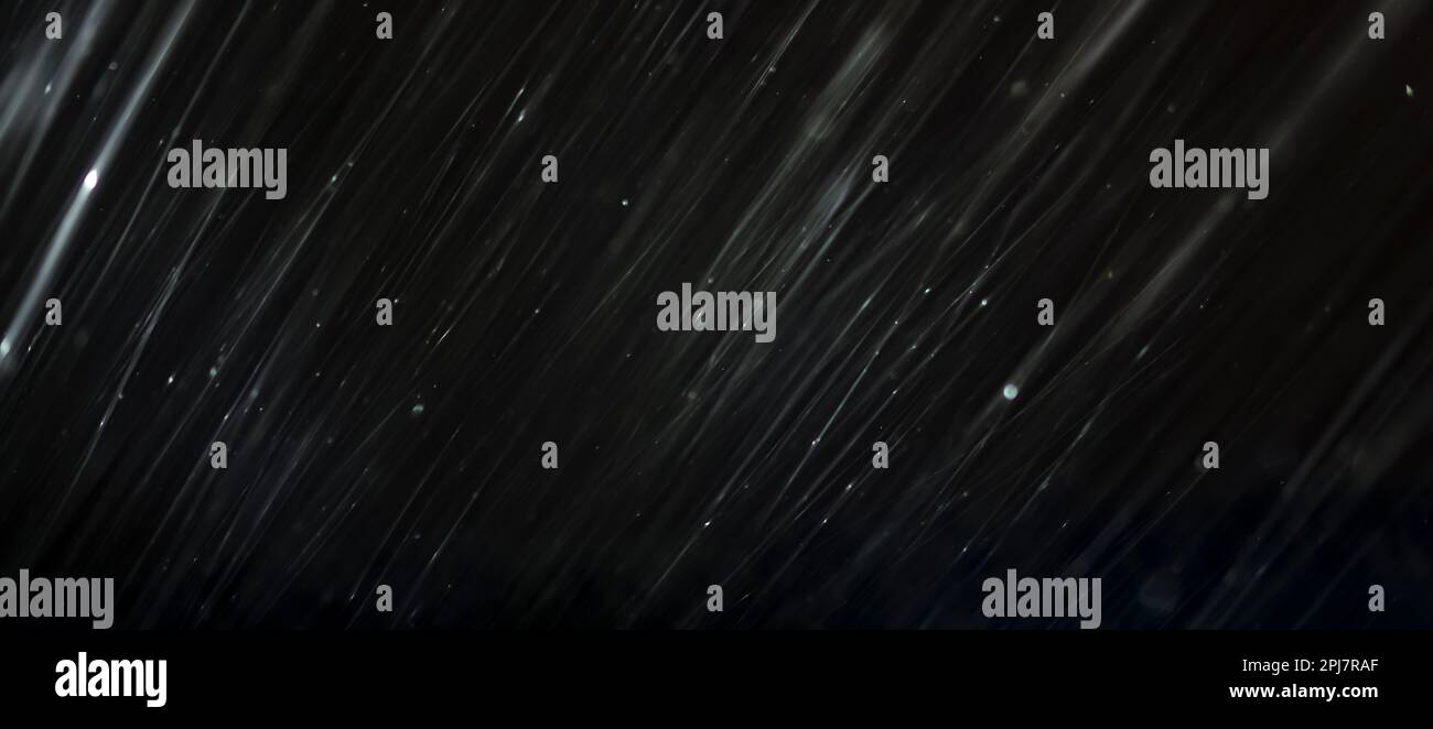 Falling streaks from white snow falling at night in the dark Stock ...