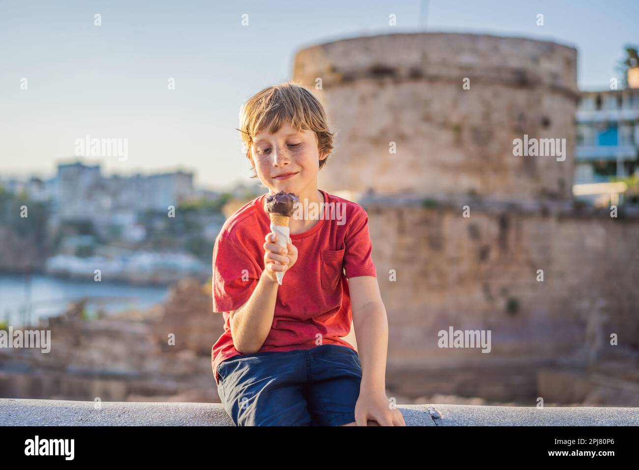 Boy tourist eating turkish ice cream on background of Hidirlik Tower in ...