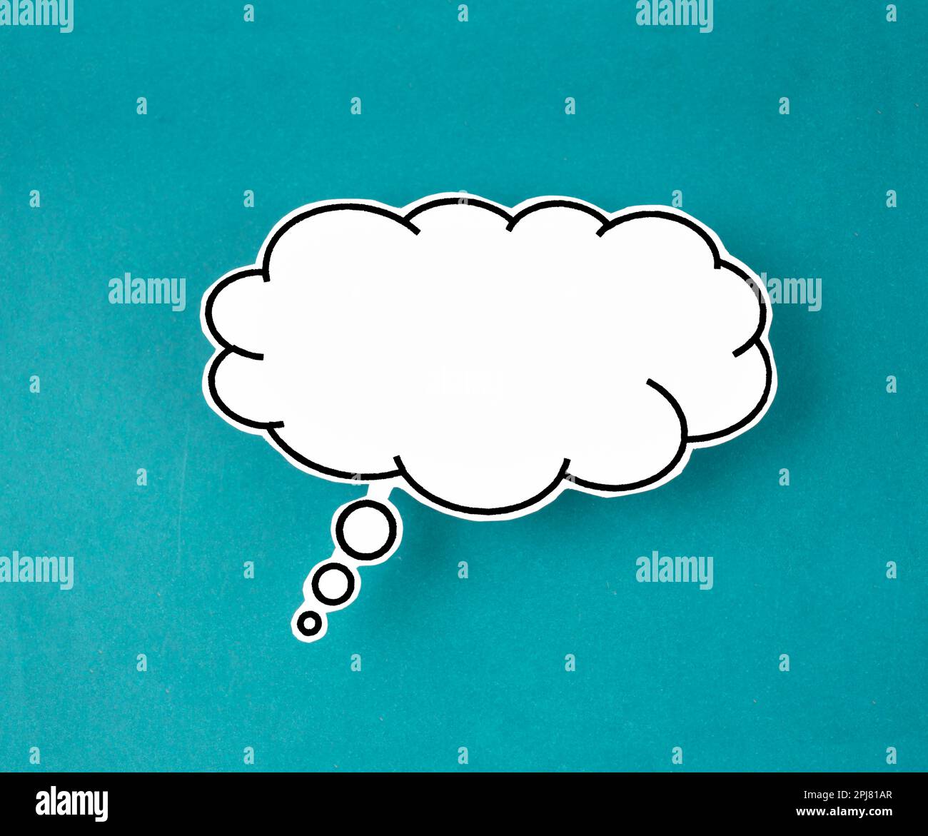 White speech bubble shaped post it note on green background with copy ...
