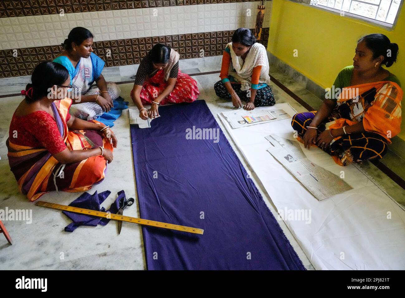 Kakali Halder, second left, watch a session of school uniform cutting ...