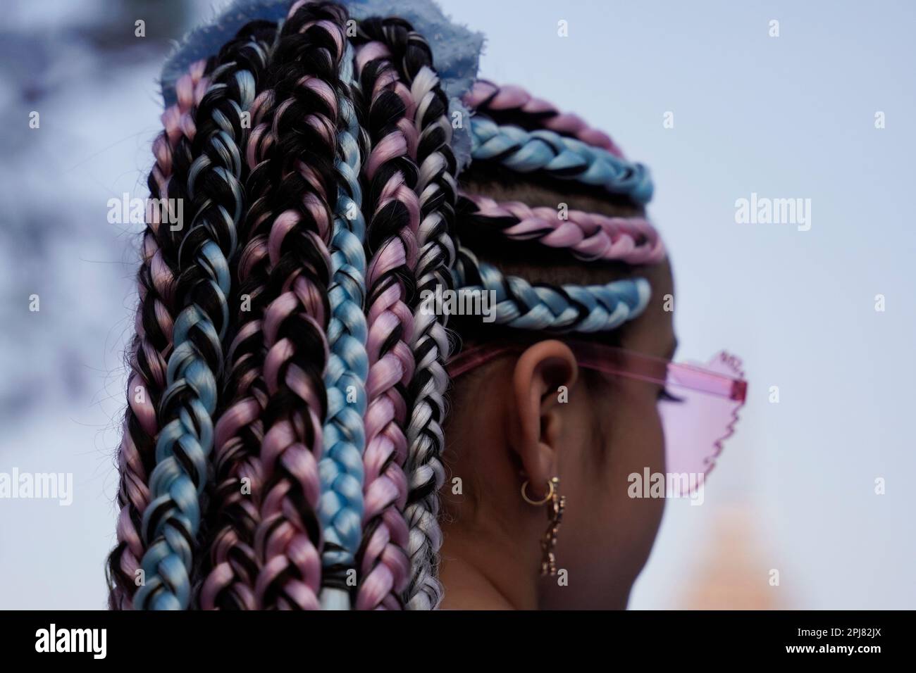 A participant, whose braids are adorned with the the colors of the ...