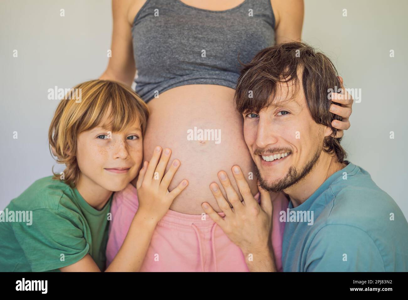 Father and elder son listen to mom's pregnant belly Stock Photo - Alamy