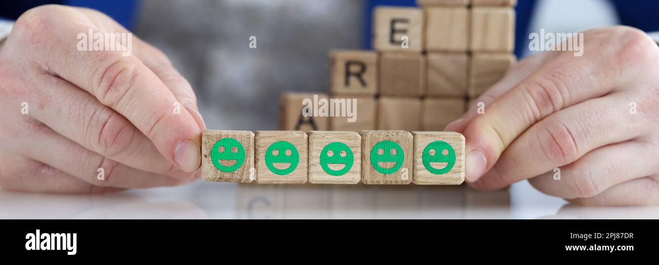 Five green smiling emoticons on cubes in hands of businessman Stock ...