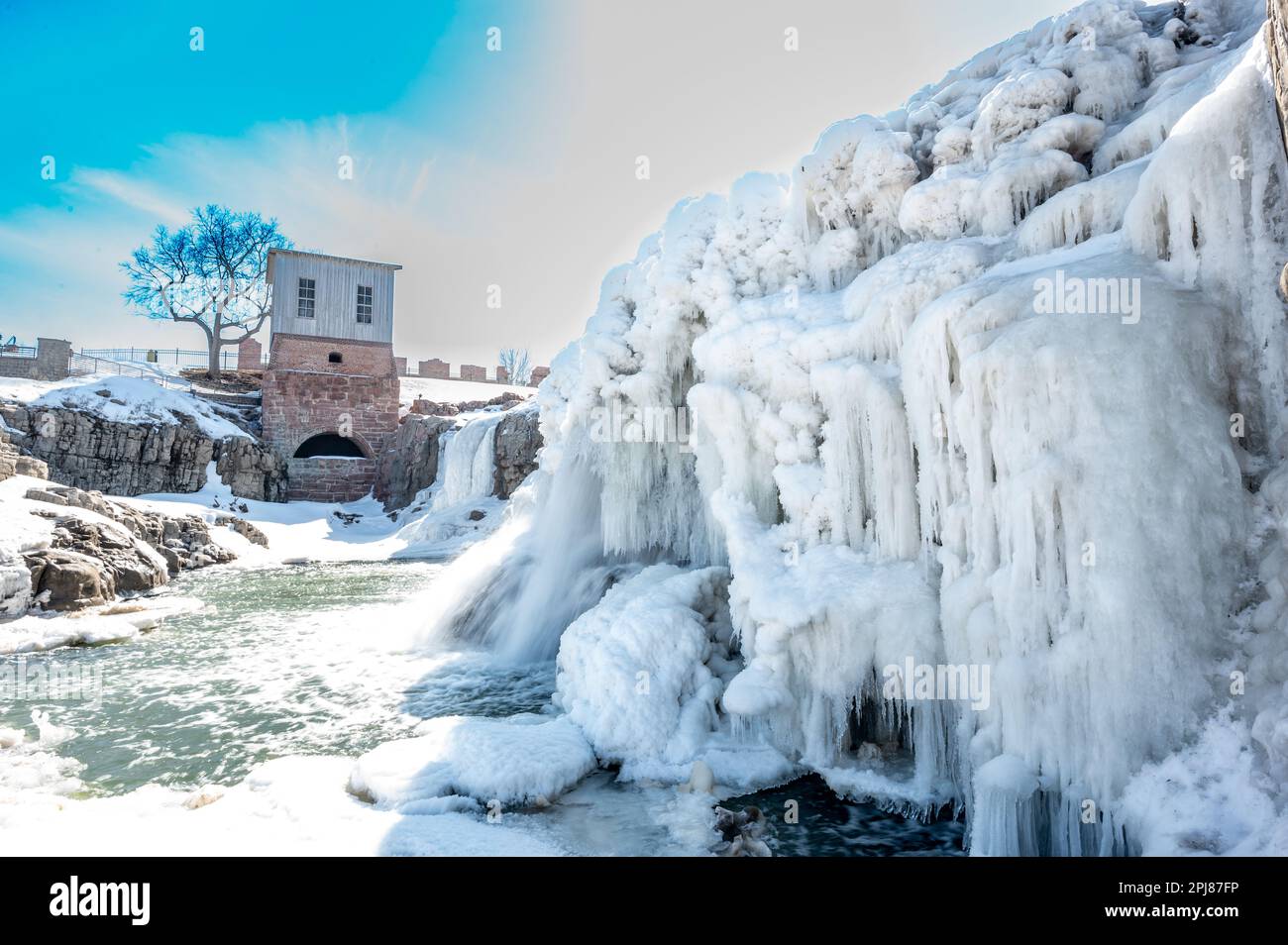 Sioux Falls Park waterfall with ice and snow. Cascading snowmelt water ...