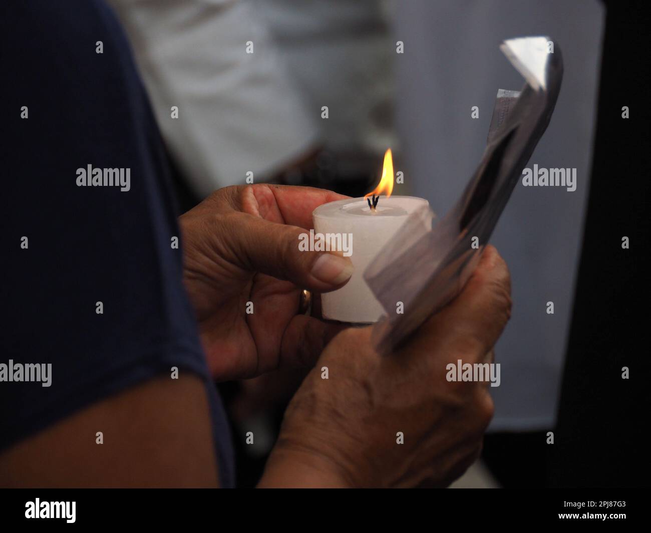 A woman holds a candle in her hands when catholic devotees stage a Via ...