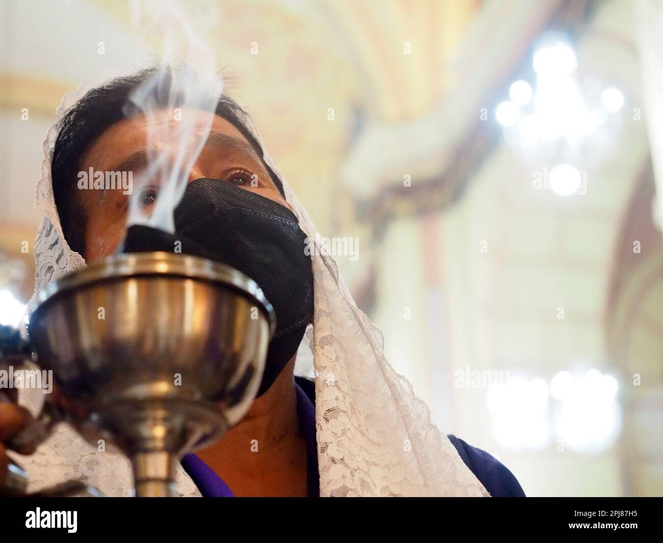 Woman wearing habit and mantilla and carrying incense burners ...