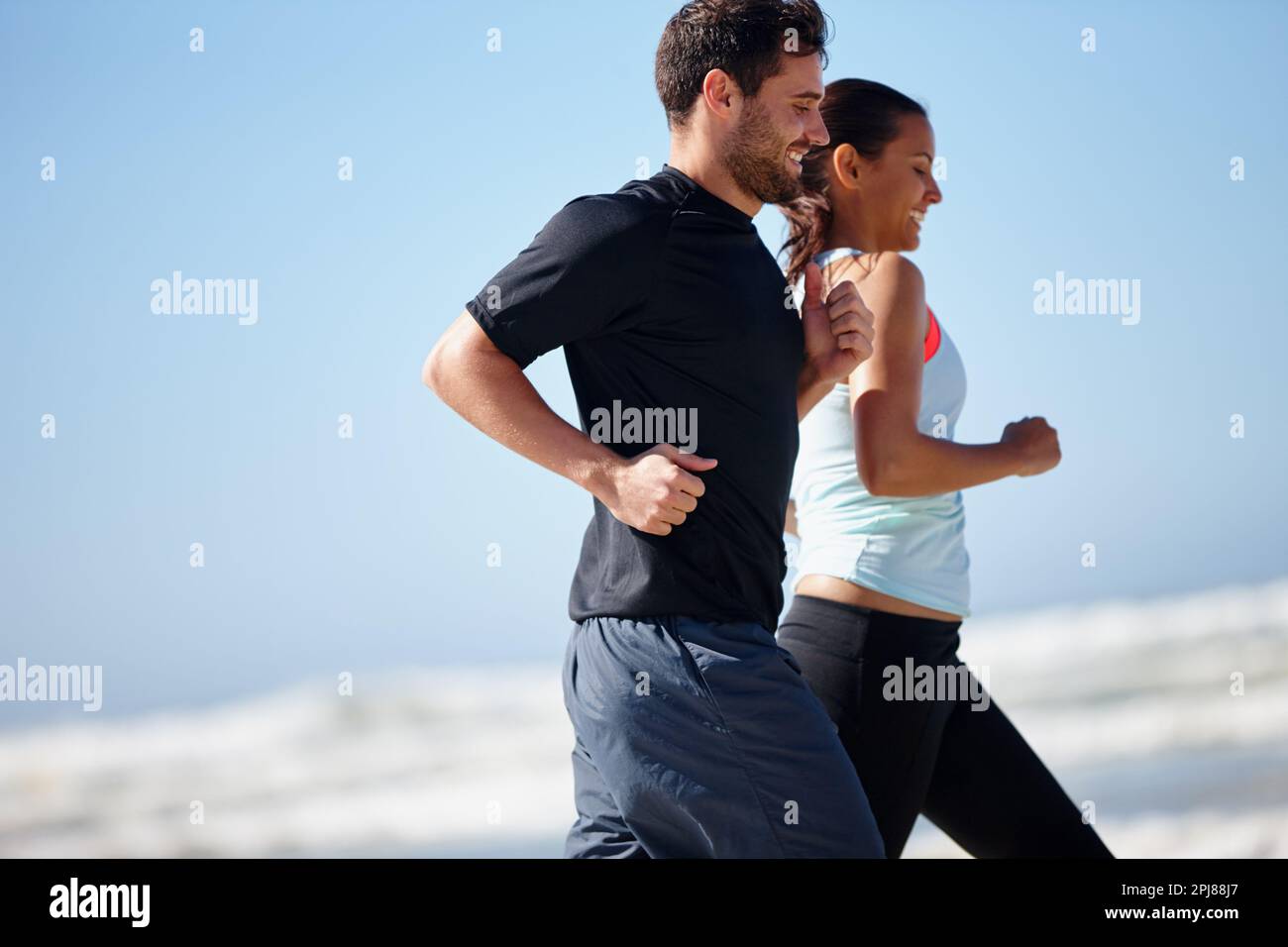 We do everything together. a happy young couple enjoying a beach run ...