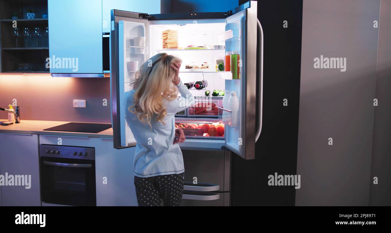 Hungry Woman At Night With Open Fridge Stock Photo - Alamy