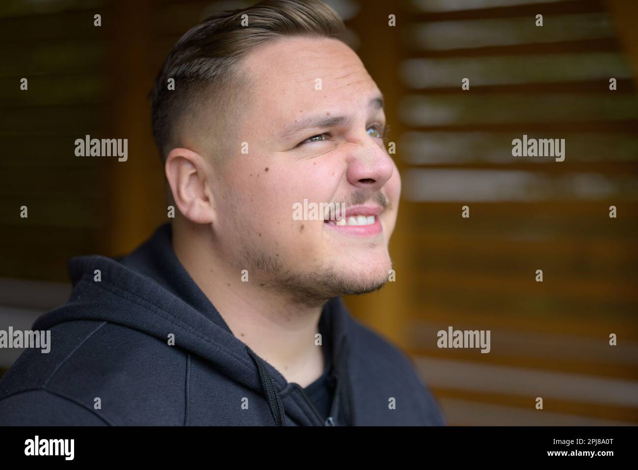 Young man with a mustache and unshaven looks up at the sky with an ...