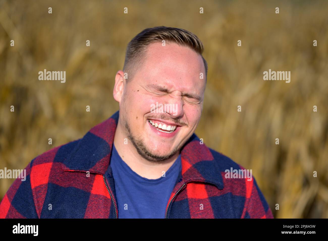 Portrait of a young man with a laughing fit of extreme joy with eyes ...