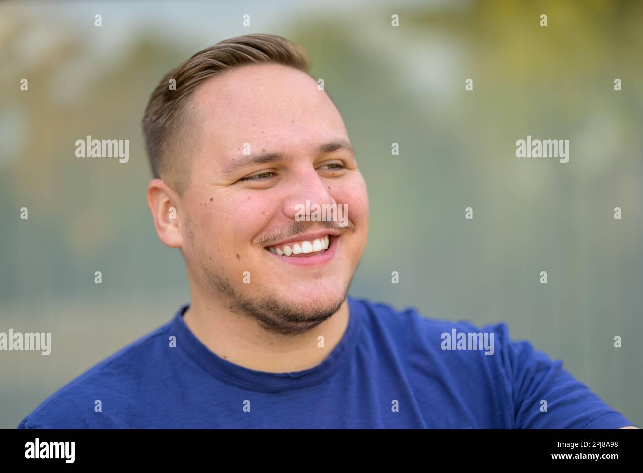 Side portrait of a young man with a big smile Stock Photo - Alamy