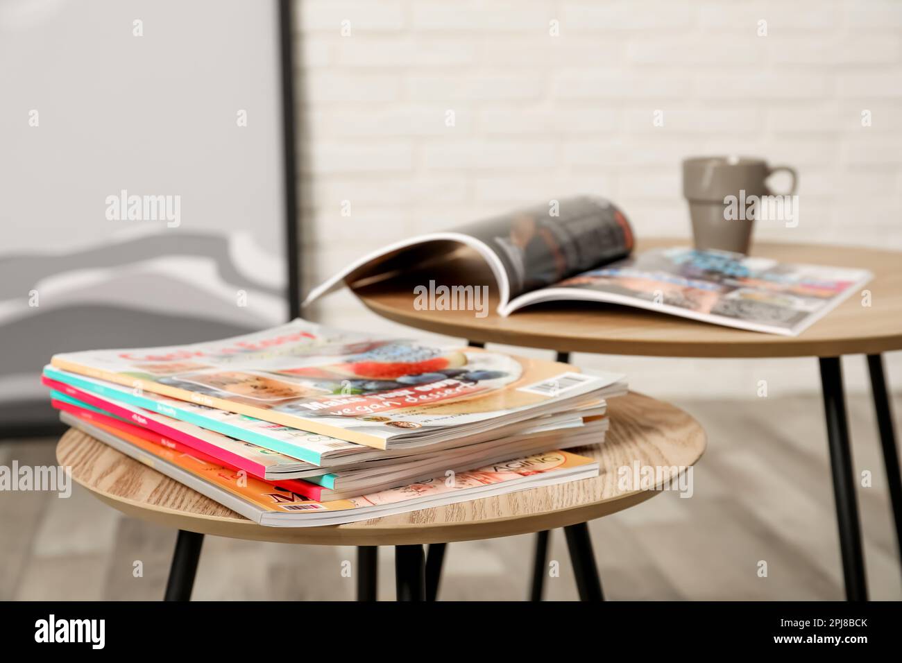 Wooden nesting tables with different magazines indoors Stock Photo - Alamy