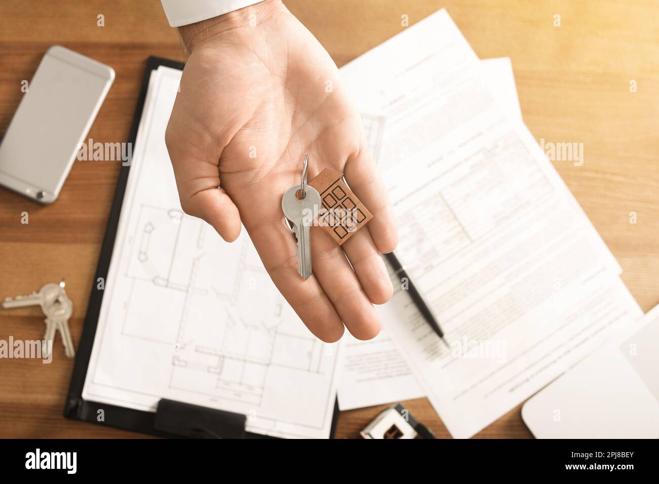 Man holding key over table in office, top view. Insurance concept Stock ...