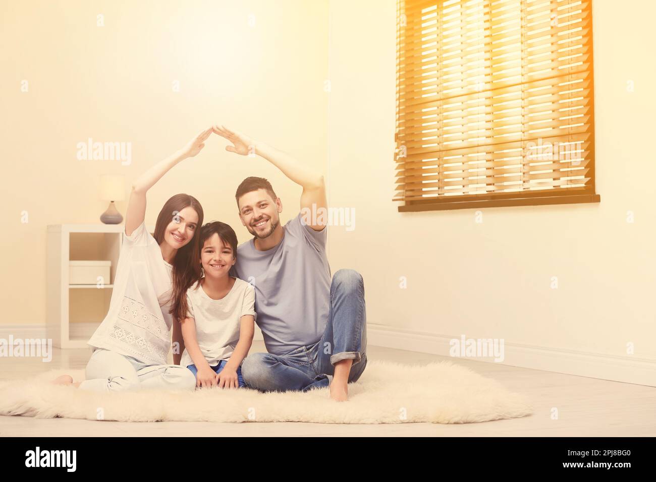 Happy family forming house roof with their hands at home. Insurance ...