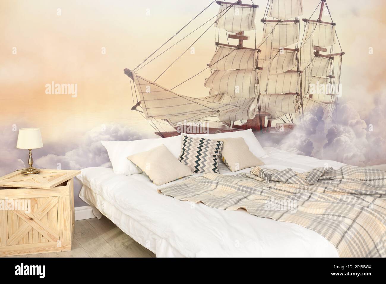 Beautiful wallpaper with image of sailing ship among wonderful fluffy clouds in bedroom interior ...