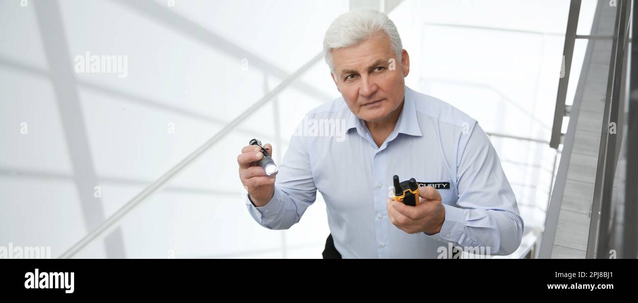 Professional security guard with flashlight and portable radio set on ...