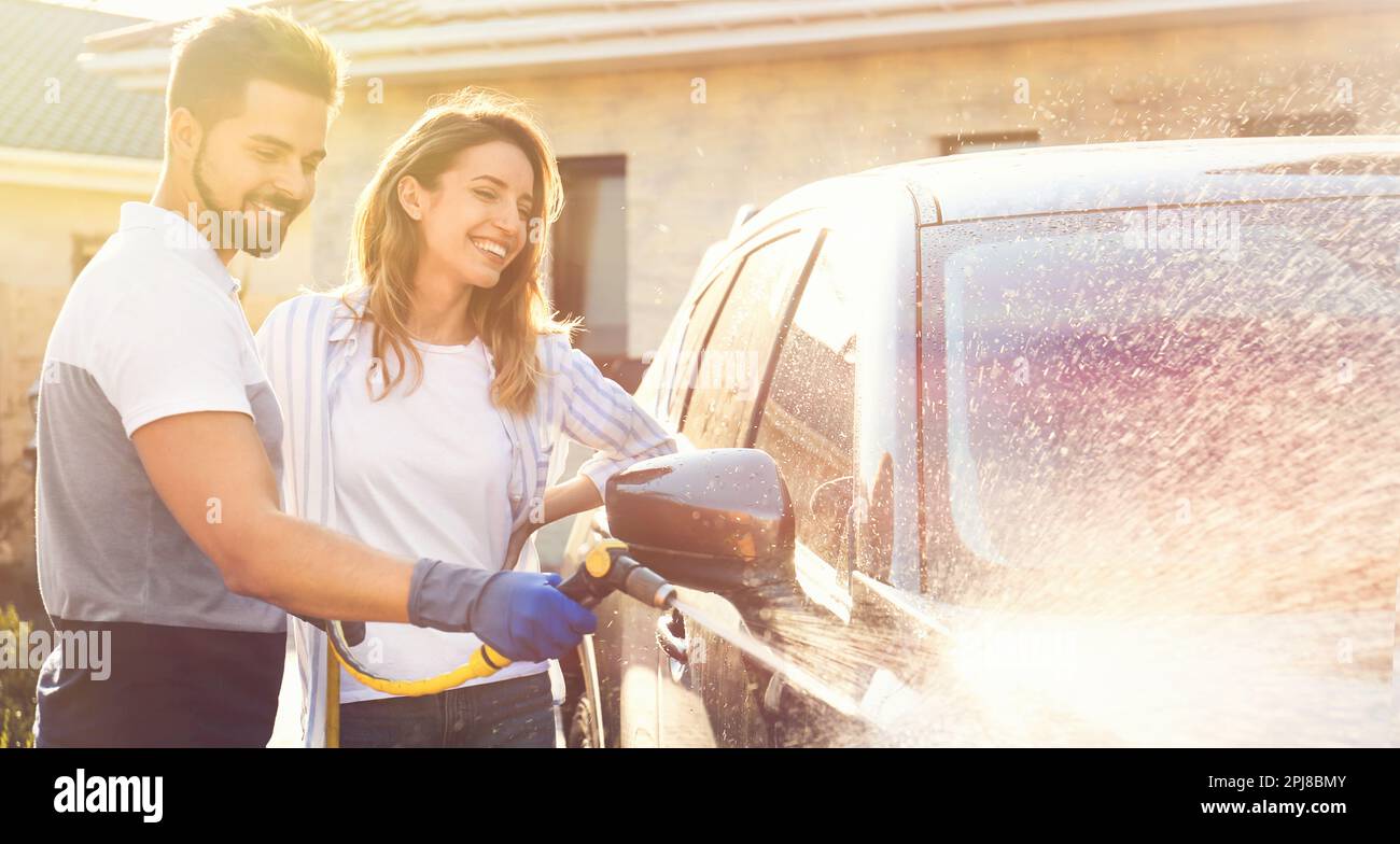 Happy young couple washing car at backyard on sunny day. Banner design ...
