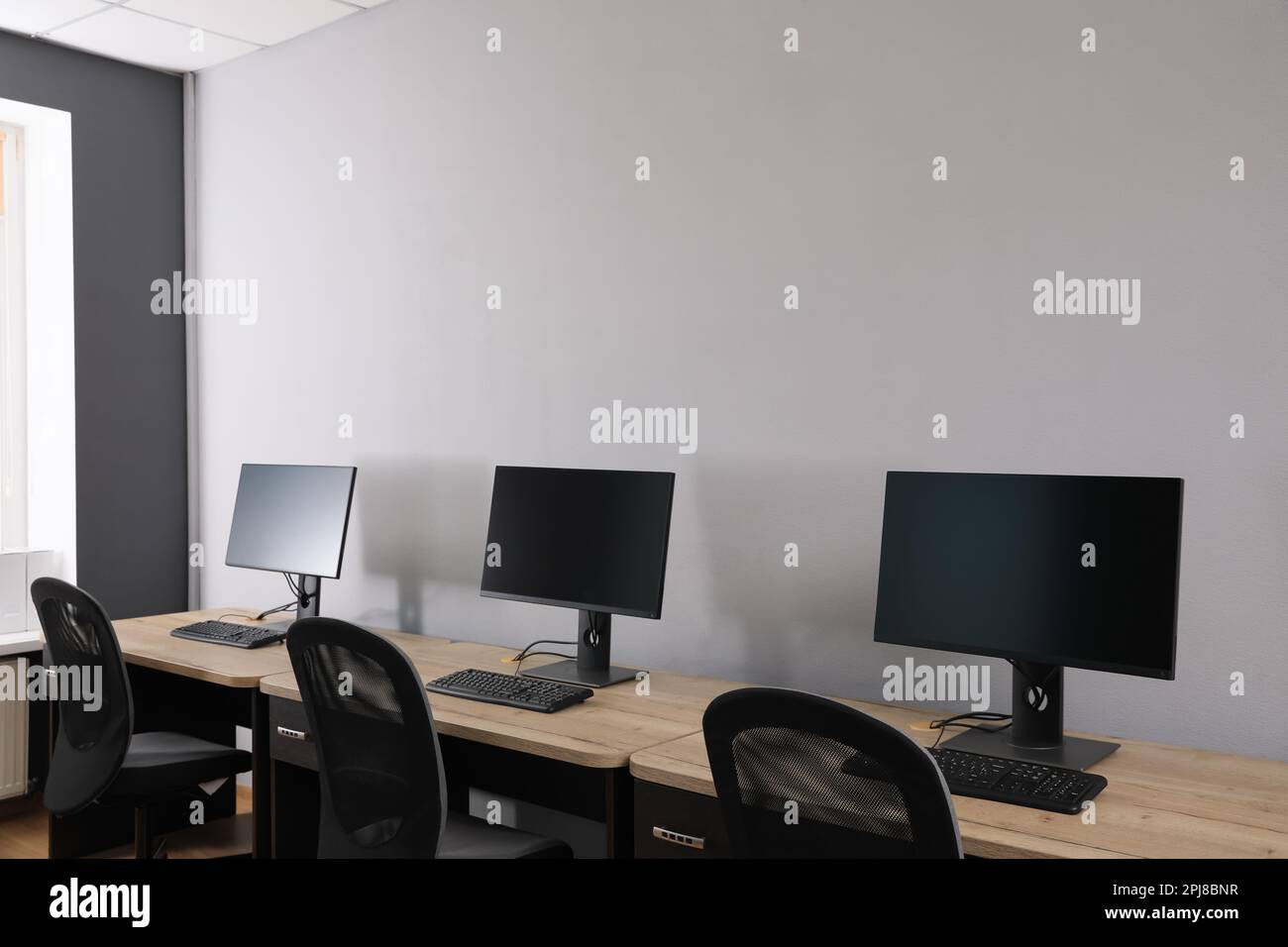 Open office interior. Modern workplaces with computers near light grey ...