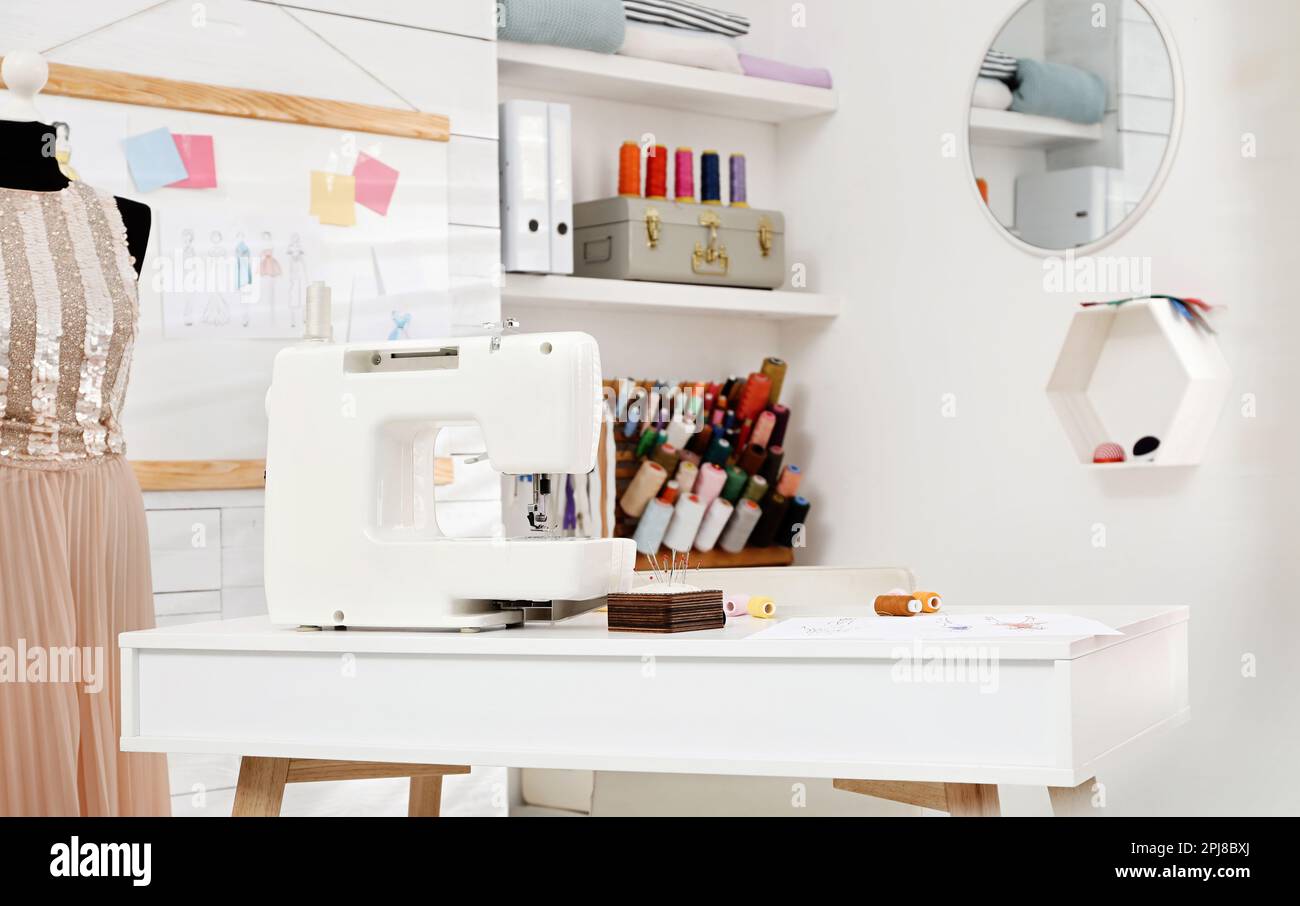 Dressmaking workshop interior with modern sewing machine, mannequin and ...