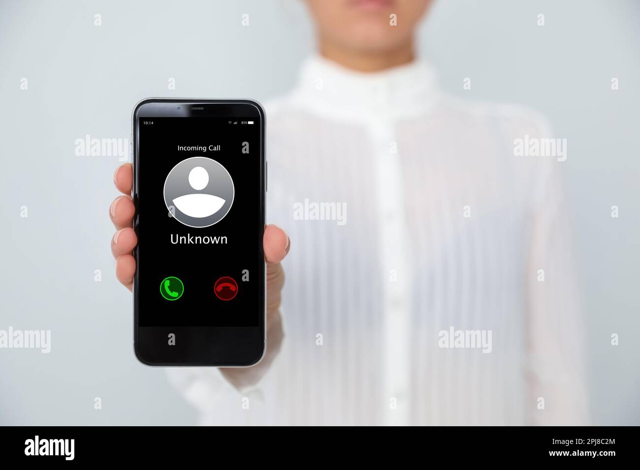 Woman showing phone with incoming call from unknown caller on white ...