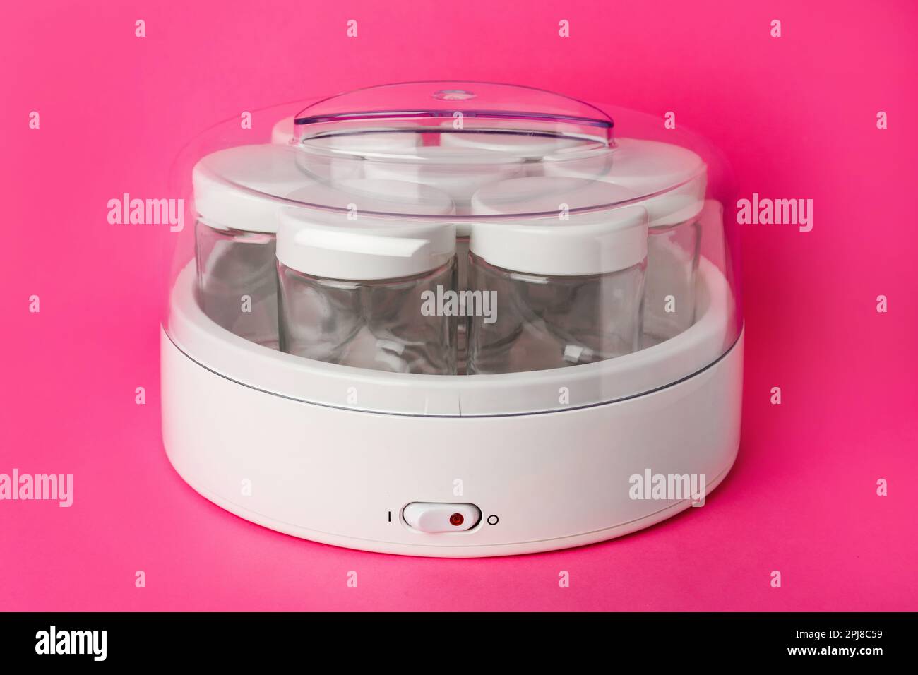 Modern yogurt maker with empty jars on pink background Stock Photo - Alamy