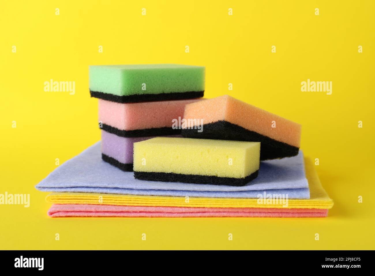 Cleaning sponges and rags on yellow background Stock Photo - Alamy