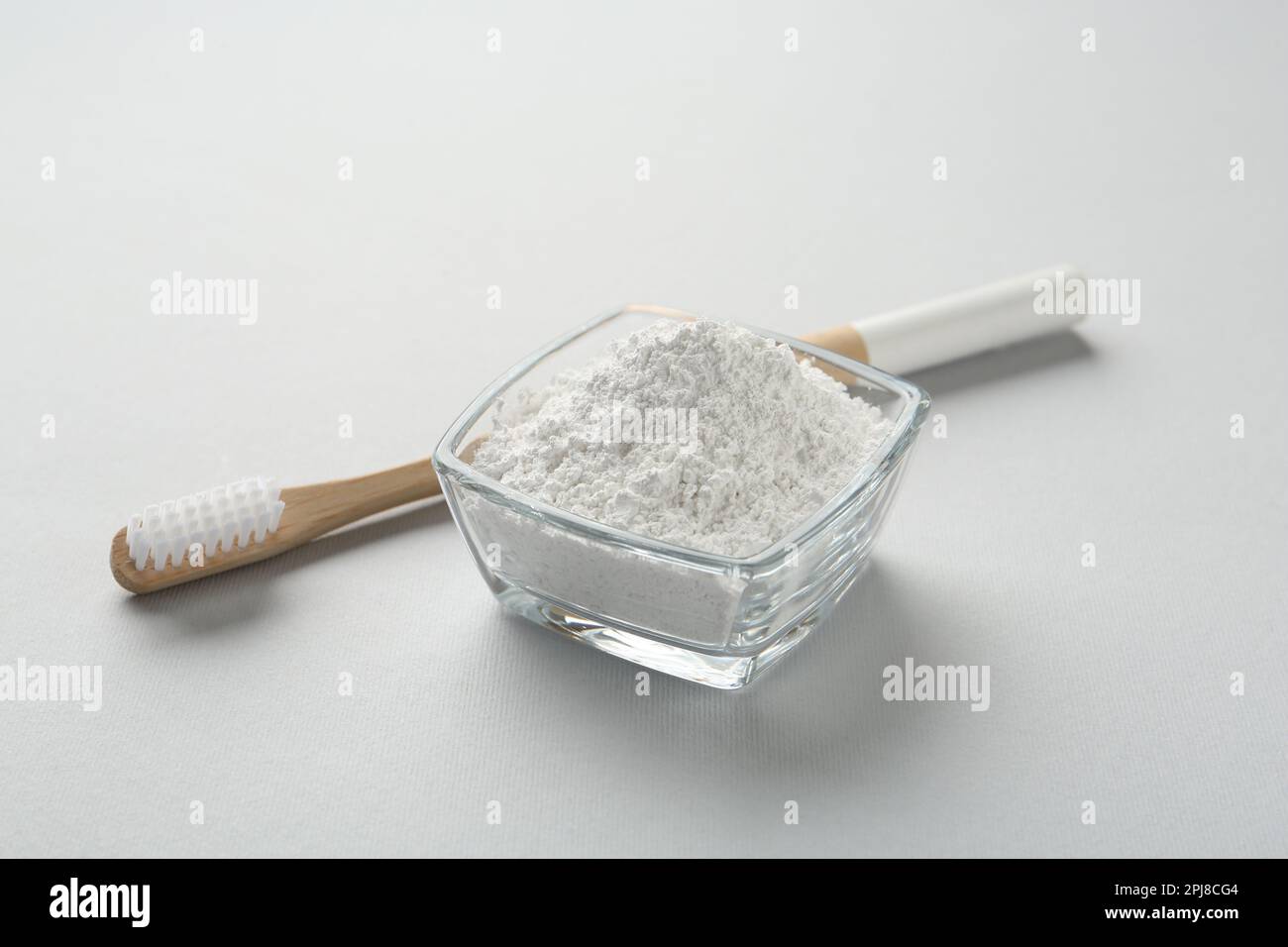 Tooth powder and brush on white background Stock Photo - Alamy