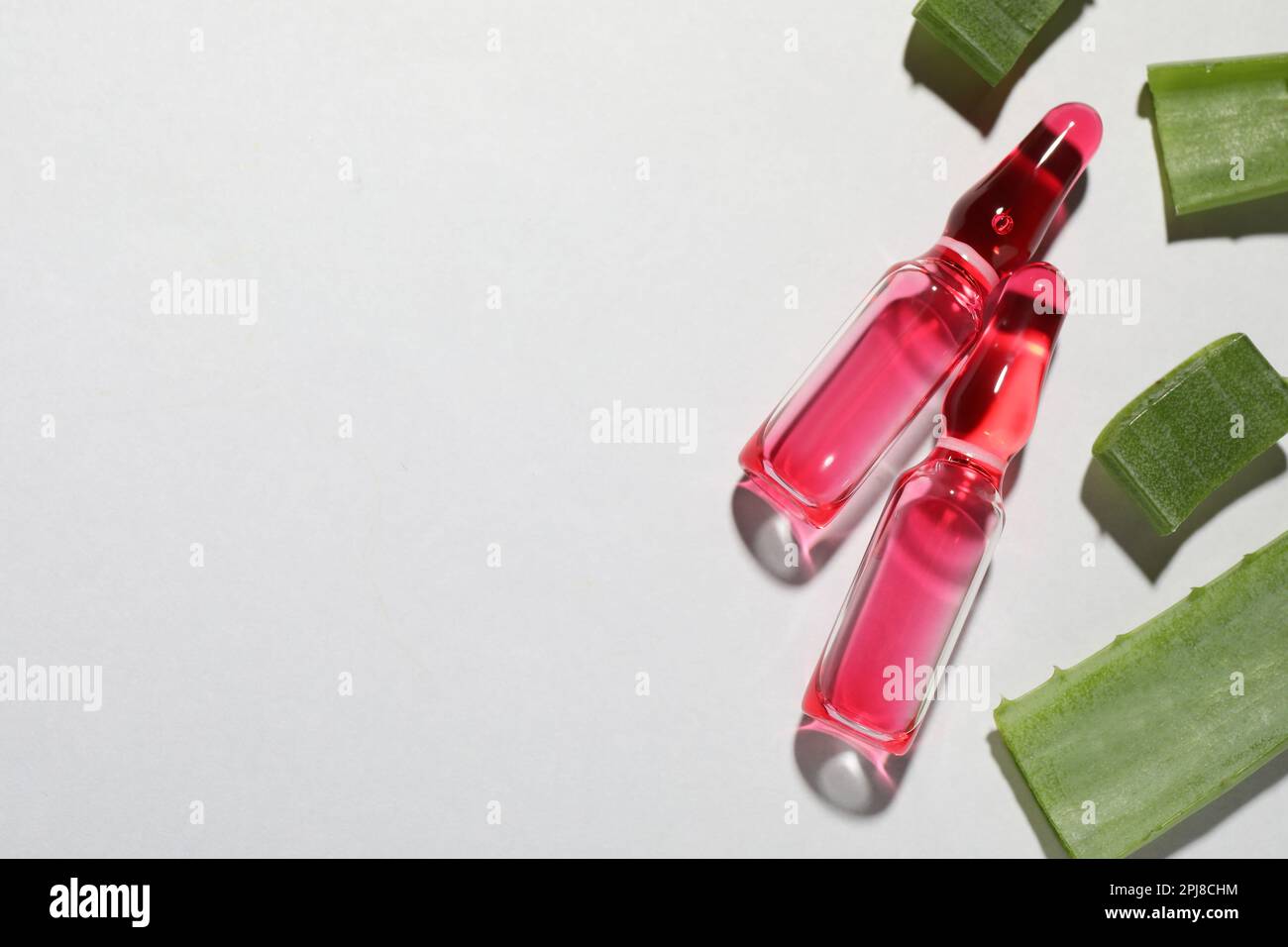 Pharmaceutical ampoules with medication and aloe leaves on light ...