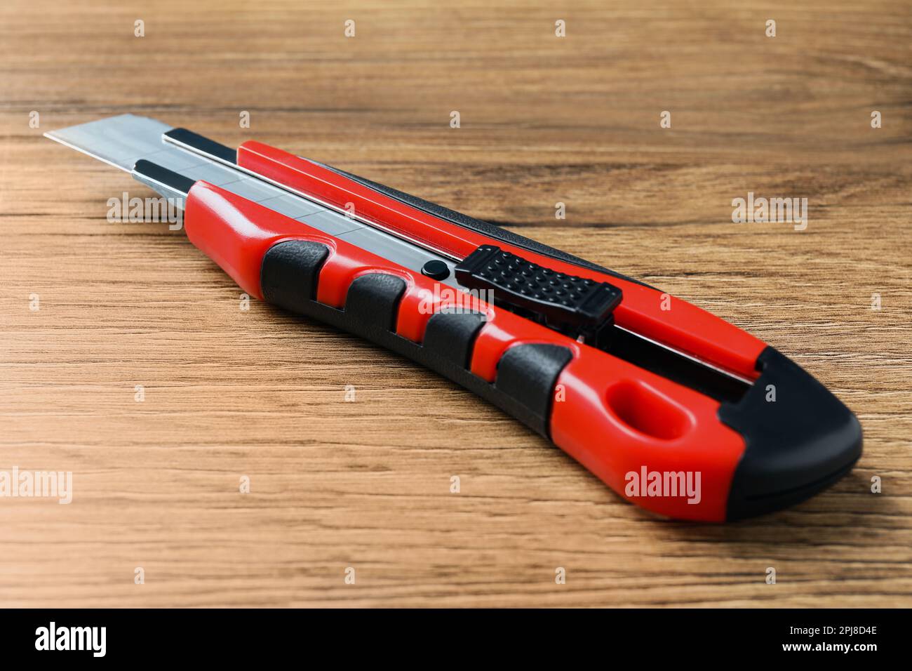 Utility knife on wooden table, closeup. Construction tool Stock Photo ...