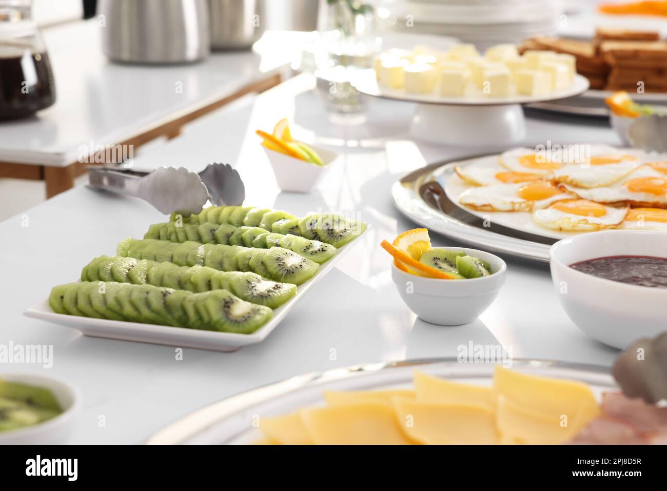 Different meals for breakfast on white table indoors. Buffet service ...